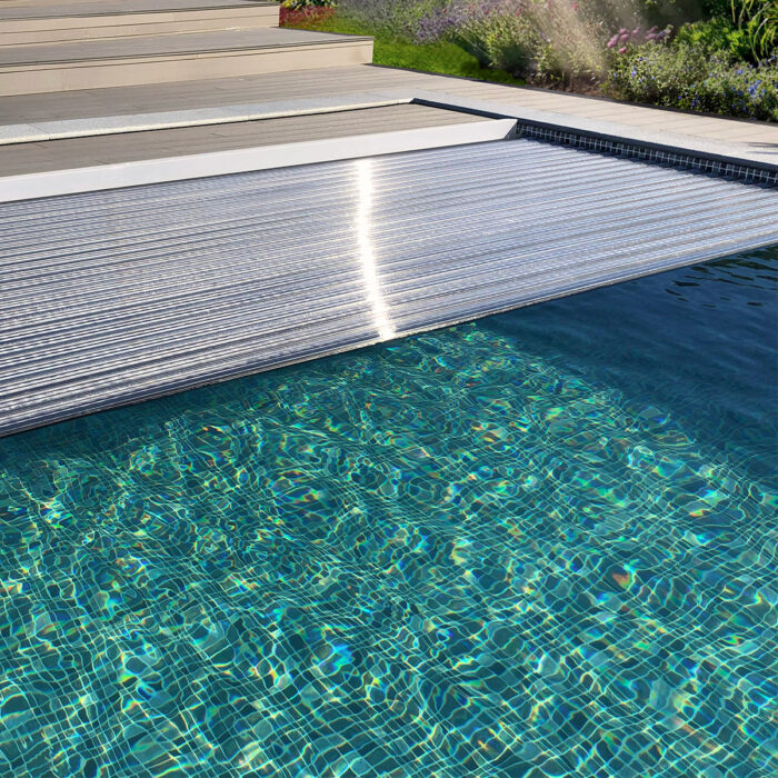 Poolsarg med kantsten runt pool. Rundad poolsarg ger skön sittyta