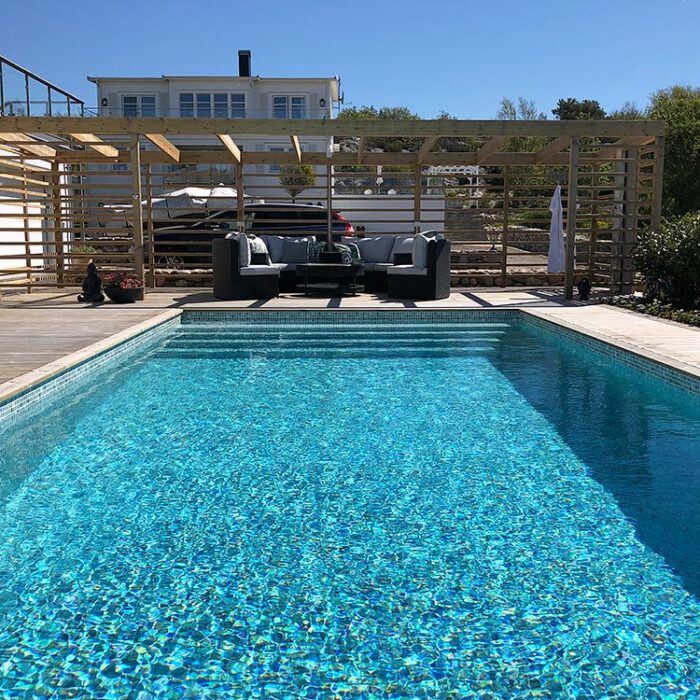 Poolsarg med kantsten runt pool. Rundad poolsarg ger skön sittyta