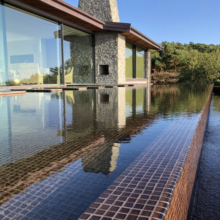 Poolsarg med kantsten runt pool. Rundad poolsarg ger skön sittyta