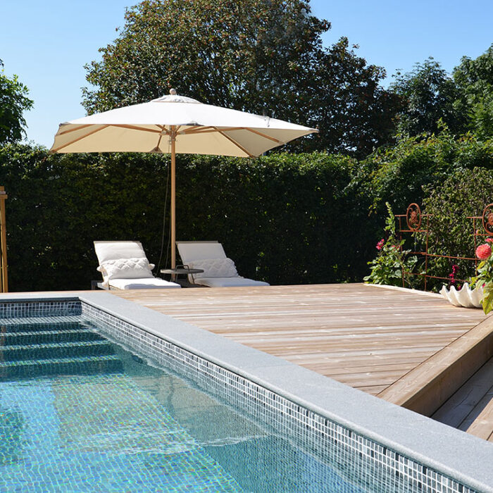 Poolsarg med kantsten runt pool. Rundad poolsarg ger skön sittyta